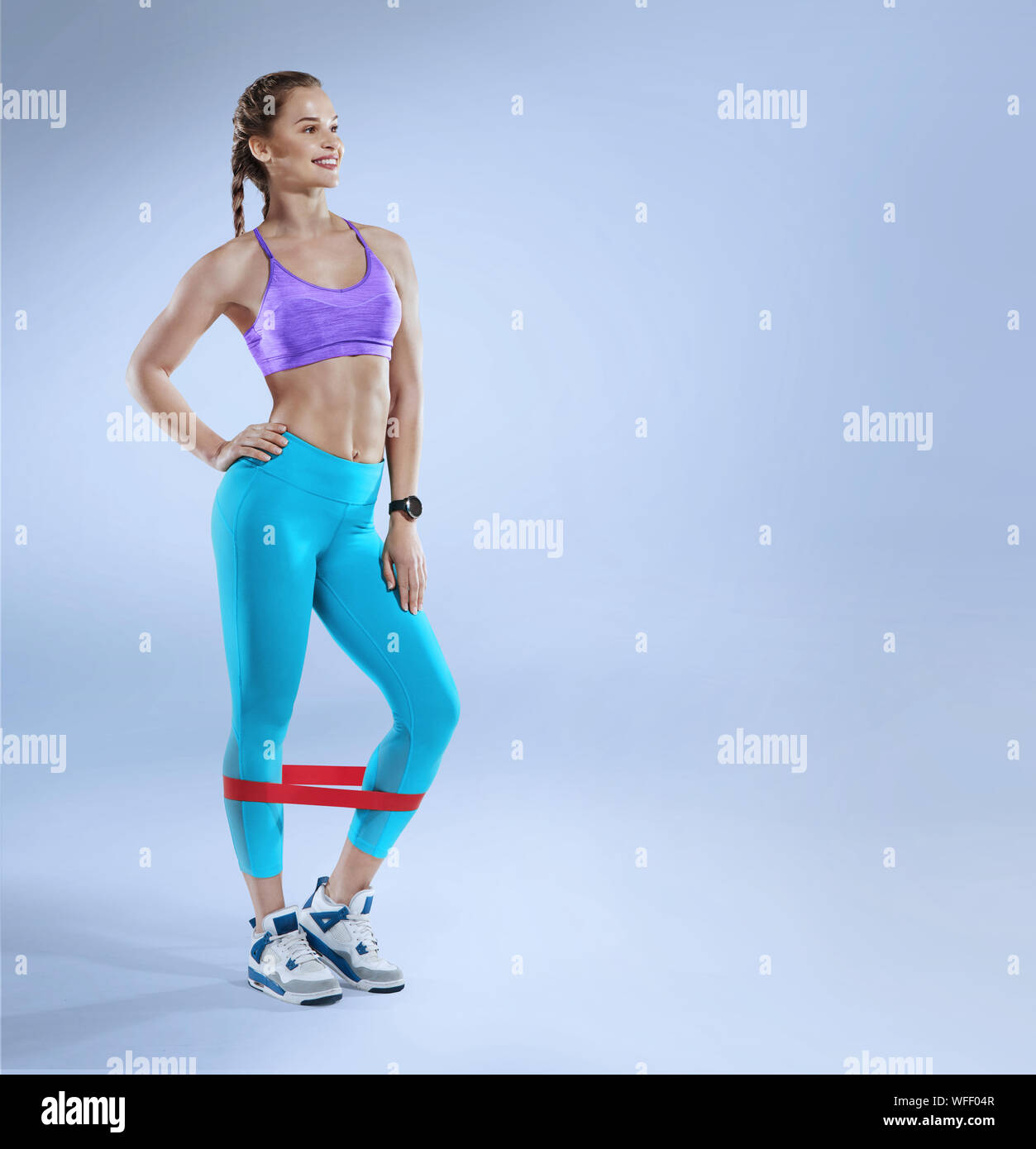 Sport. Muscular woman on a plank position use fitness gum. Muscular and ...
