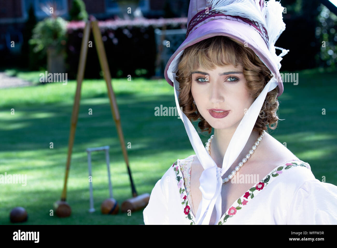 Beautiful woman in vintage Georgian dress and bonnet sitting in front ...