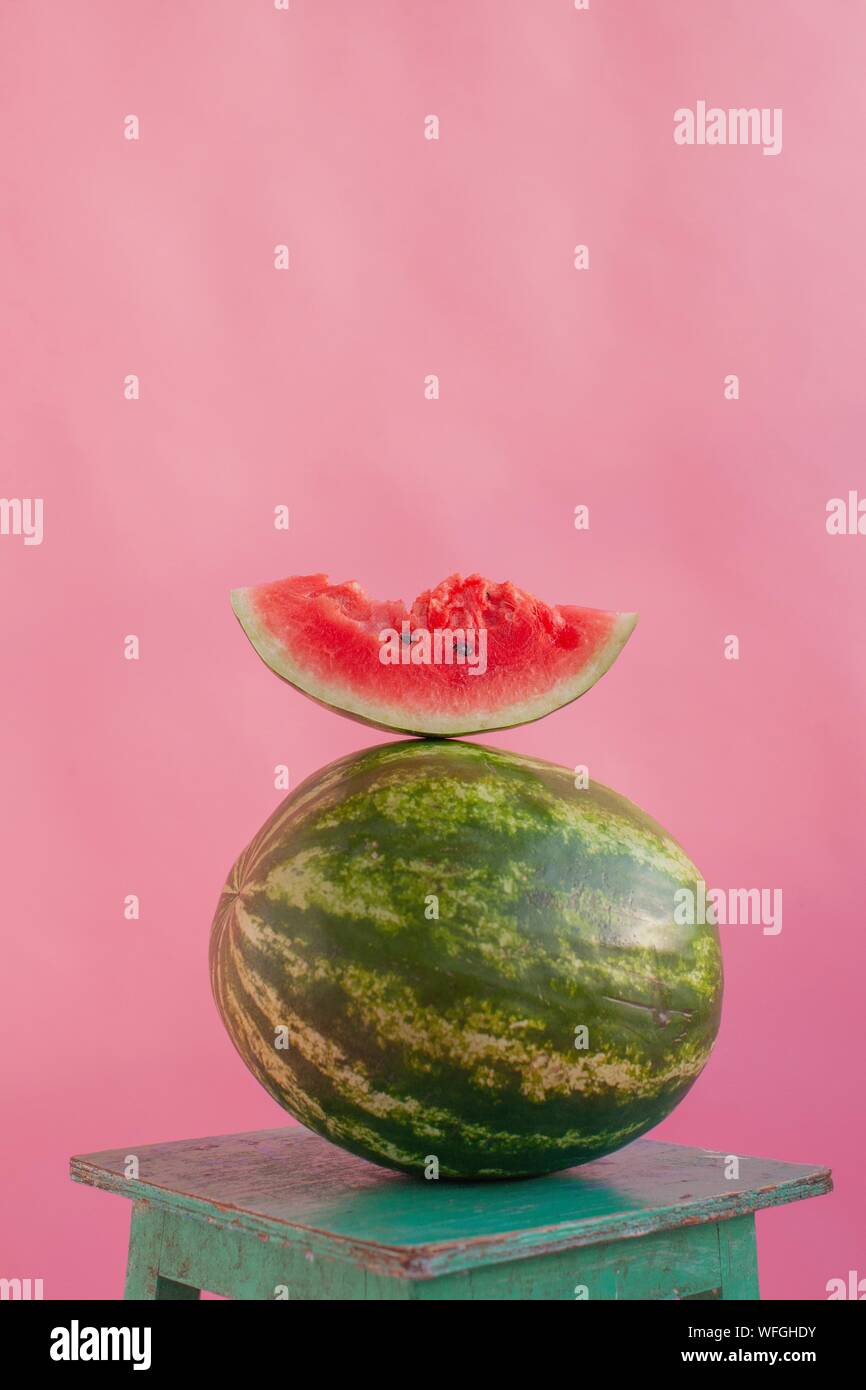 Watermelon and a slice of watermelon on a stool Stock Photo - Alamy