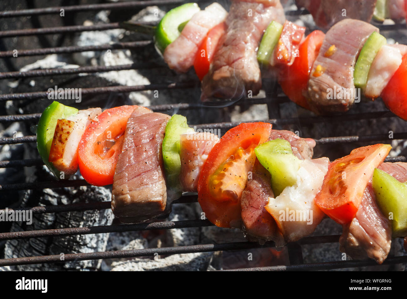 Beef brochettes grilling on the rack of a barbecue Stock Photo - Alamy