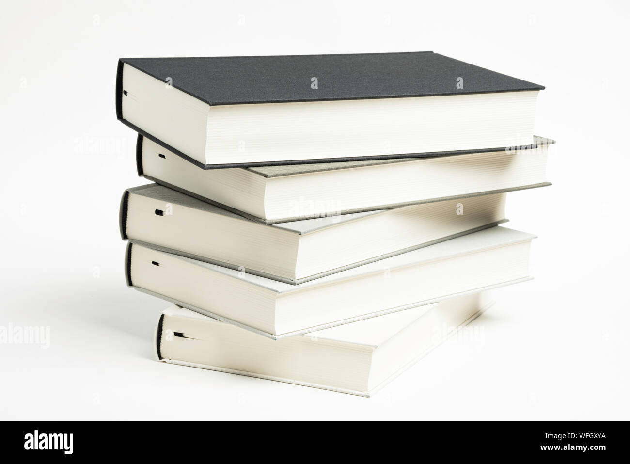 A disarrayed stack of five monochromatic cloth-bound books set on a ...