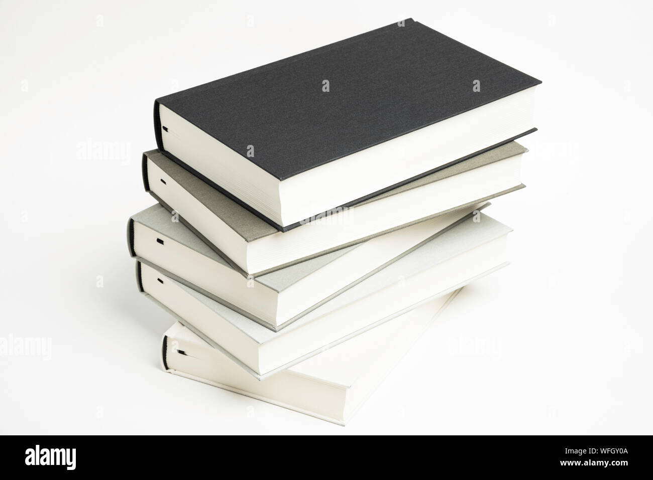 A disarrayed stack of five monochromatic cloth-bound books set on a ...