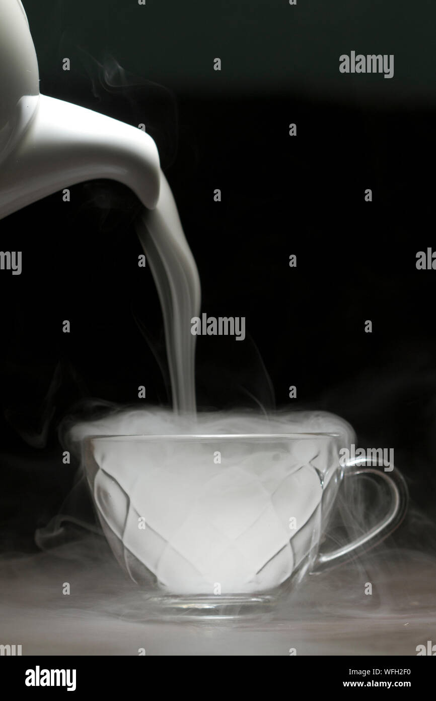 Steam being poured out of a teapot into a teacup Stock Photo - Alamy