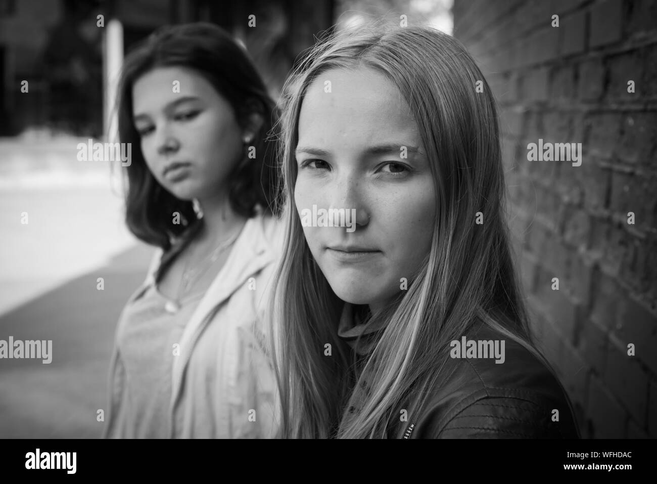 Two girls standing against wall hi-res stock photography and images - Alamy