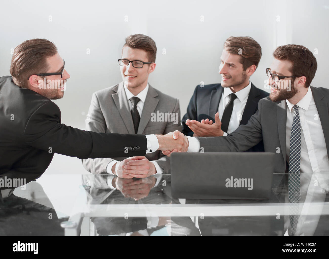 employees greet each other with a handshake Stock Photo - Alamy
