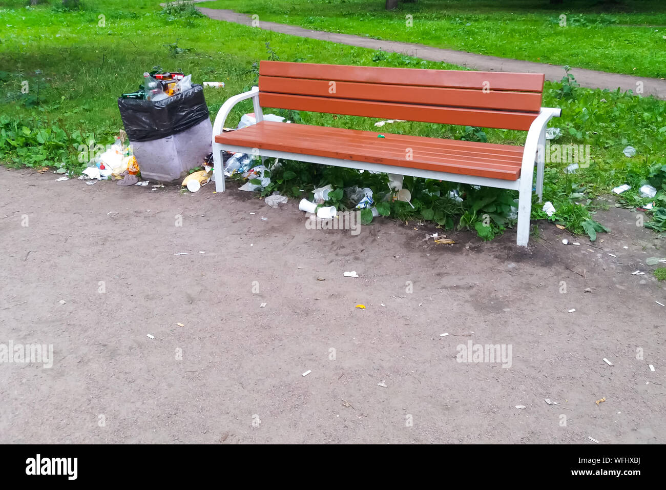 Full litter bin in the park next to the bench Stock Photo - Alamy