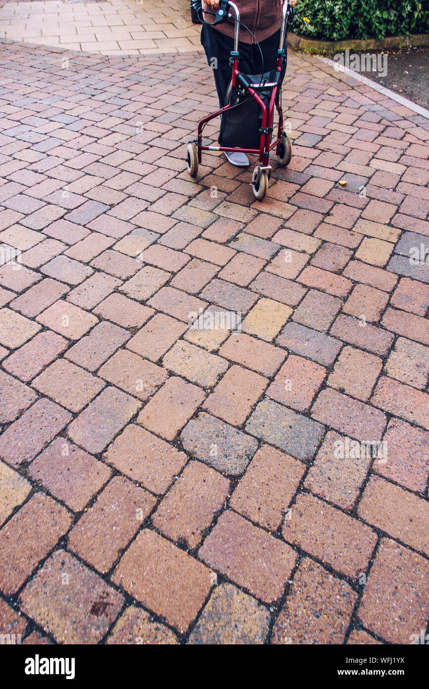 Elderly person using a 3 wheel Rollator walking aid Stock Photo - Alamy