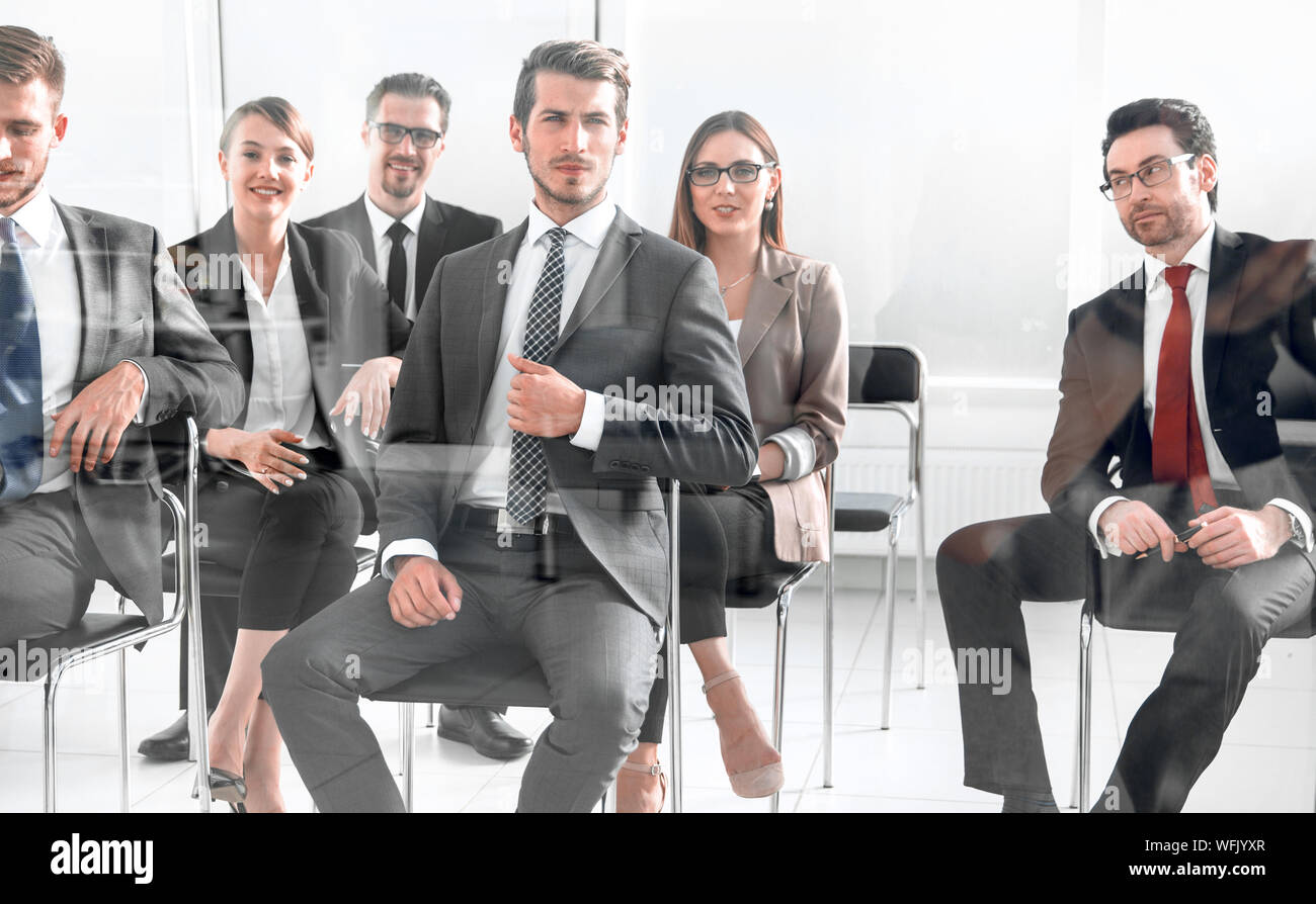 Man and women sitting on chairs in row Stock Photo - Alamy