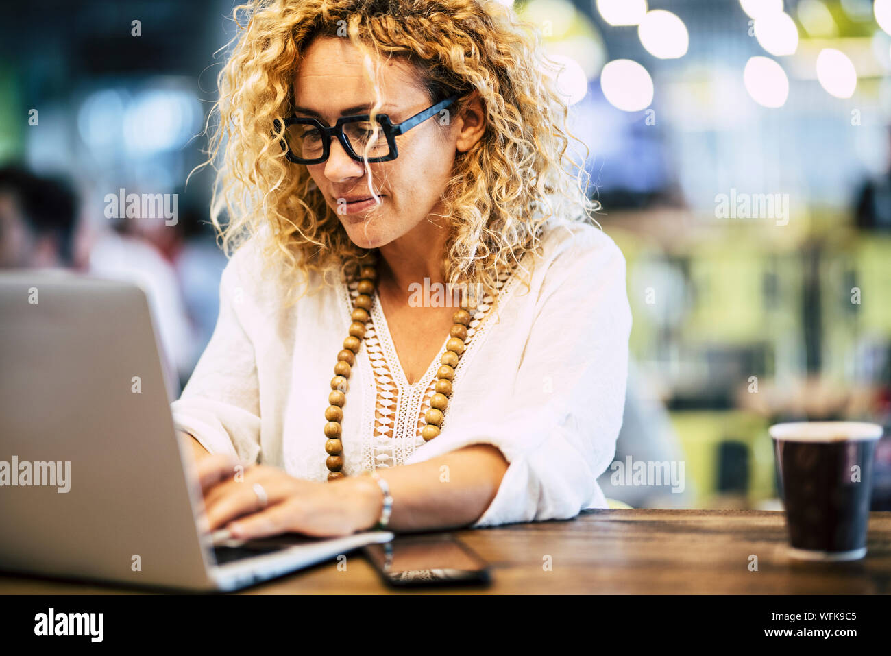 Modern adult caucasian woman working on a laptop computer at her ...