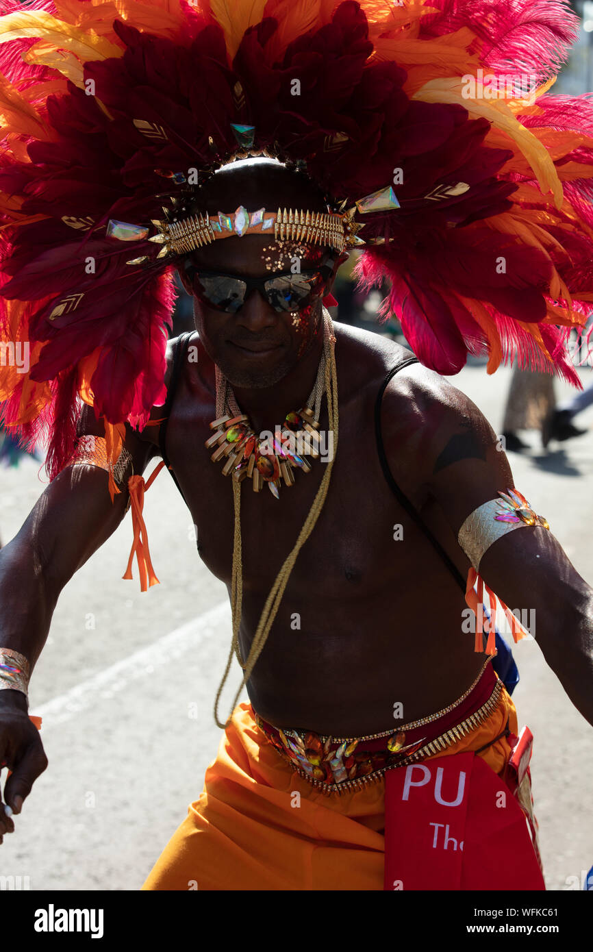 Close up of a male performer in a bright outfit with feathers of ...