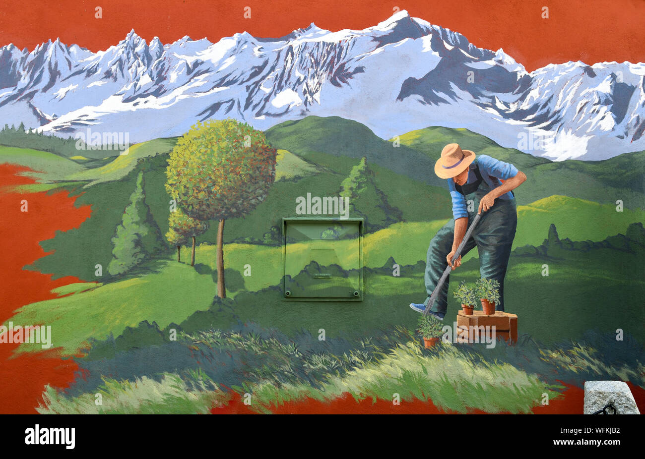 Close-up of a colorful wall painting representing a man digging a field ...