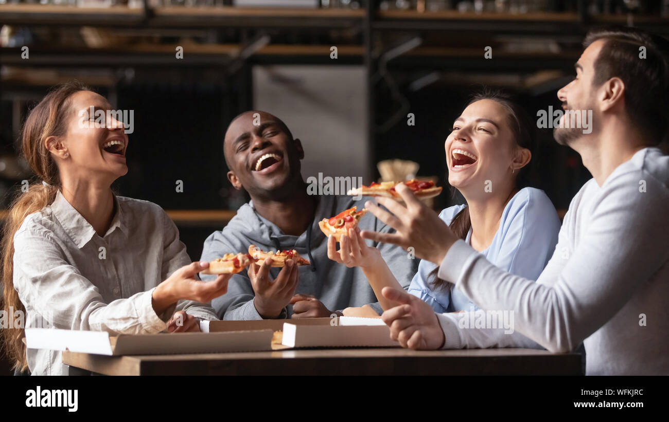 Happy diverse friends laughing at funny joke share pizza Stock Photo ...