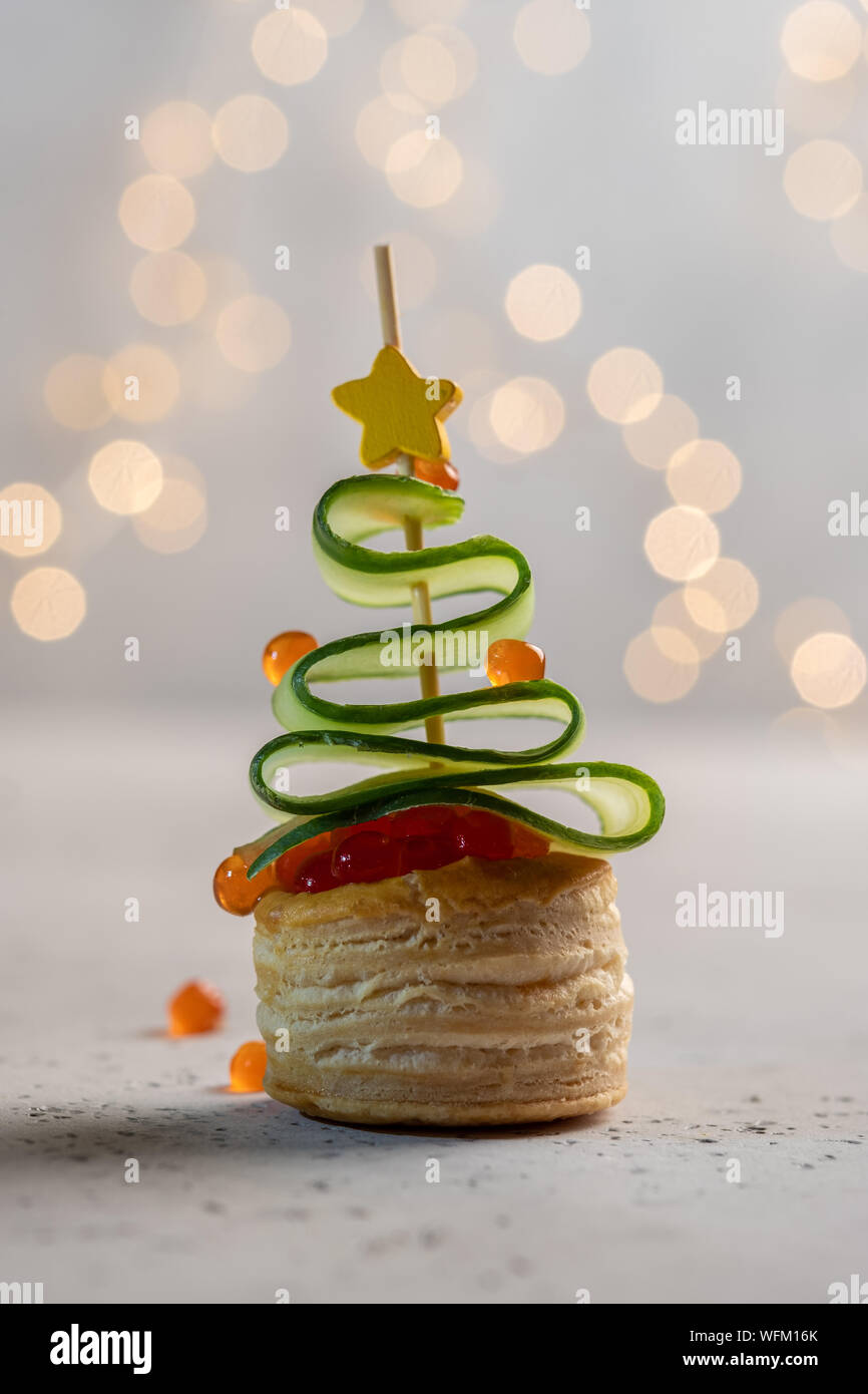 Christmas tree canape with cucumber slice, salmon pate and red caviar ...