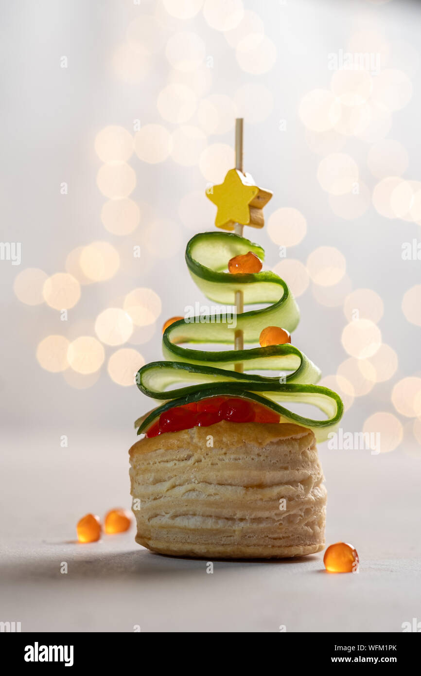 Christmas tree canape with cucumber slice, salmon pate and red caviar ...