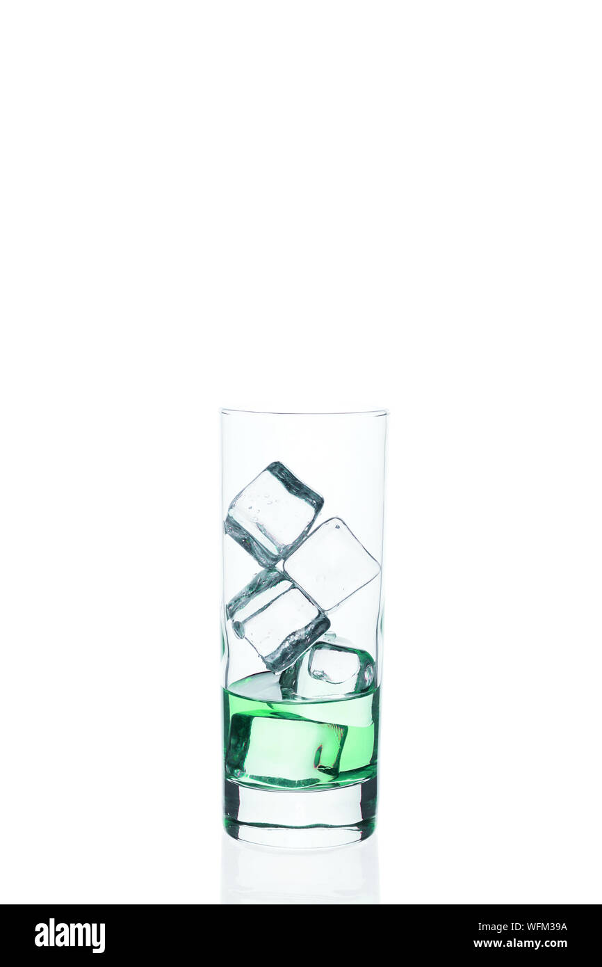 Green drink with ice cubes in a glass on a white background. Chilled ...