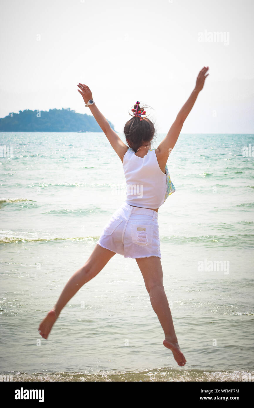 Woman arms raised jumping on beach hi-res stock photography and images ...