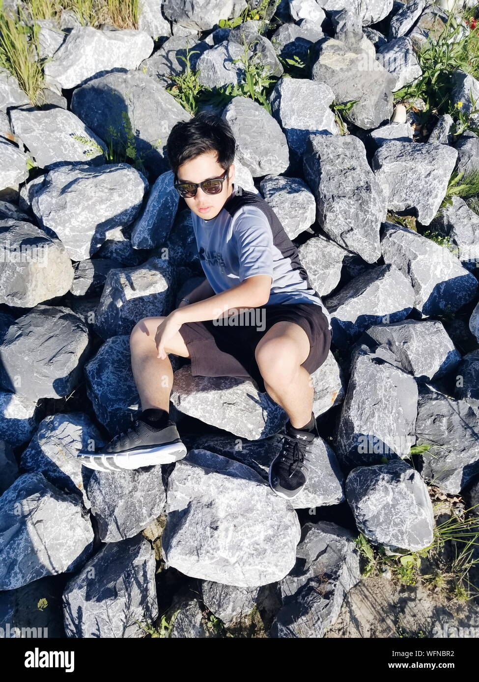 Boy sitting on rocks hi-res stock photography and images - Alamy