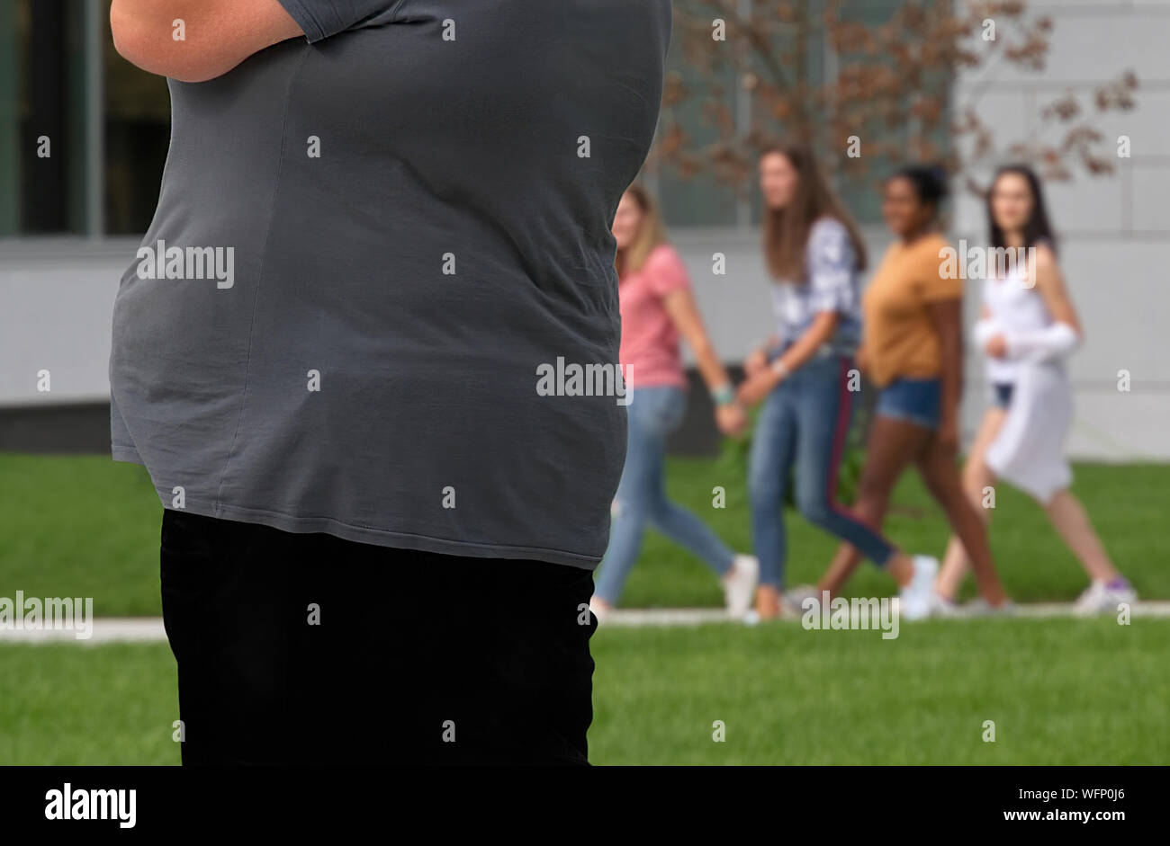 An obese individual being looked upon by a group of young women ...