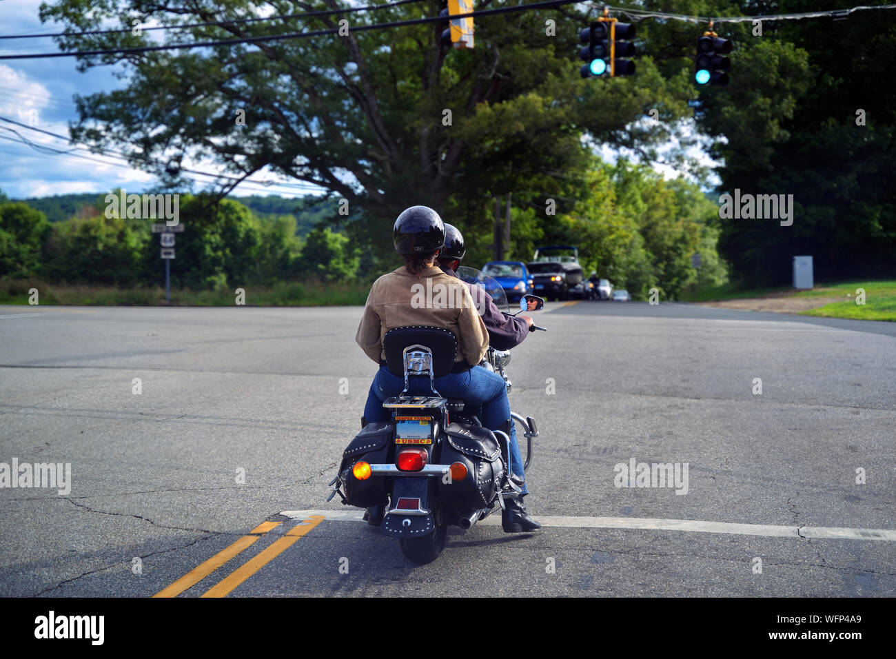 Storrs, CT USA. Aug 2019. Couple on motorcycle making a left turn at an ...