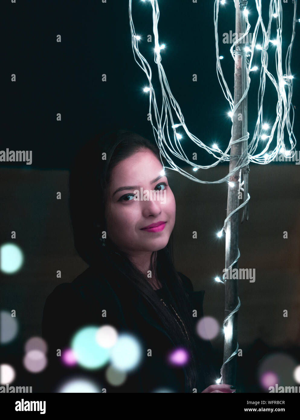 Woman hanging up lights hi-res stock photography and images - Alamy