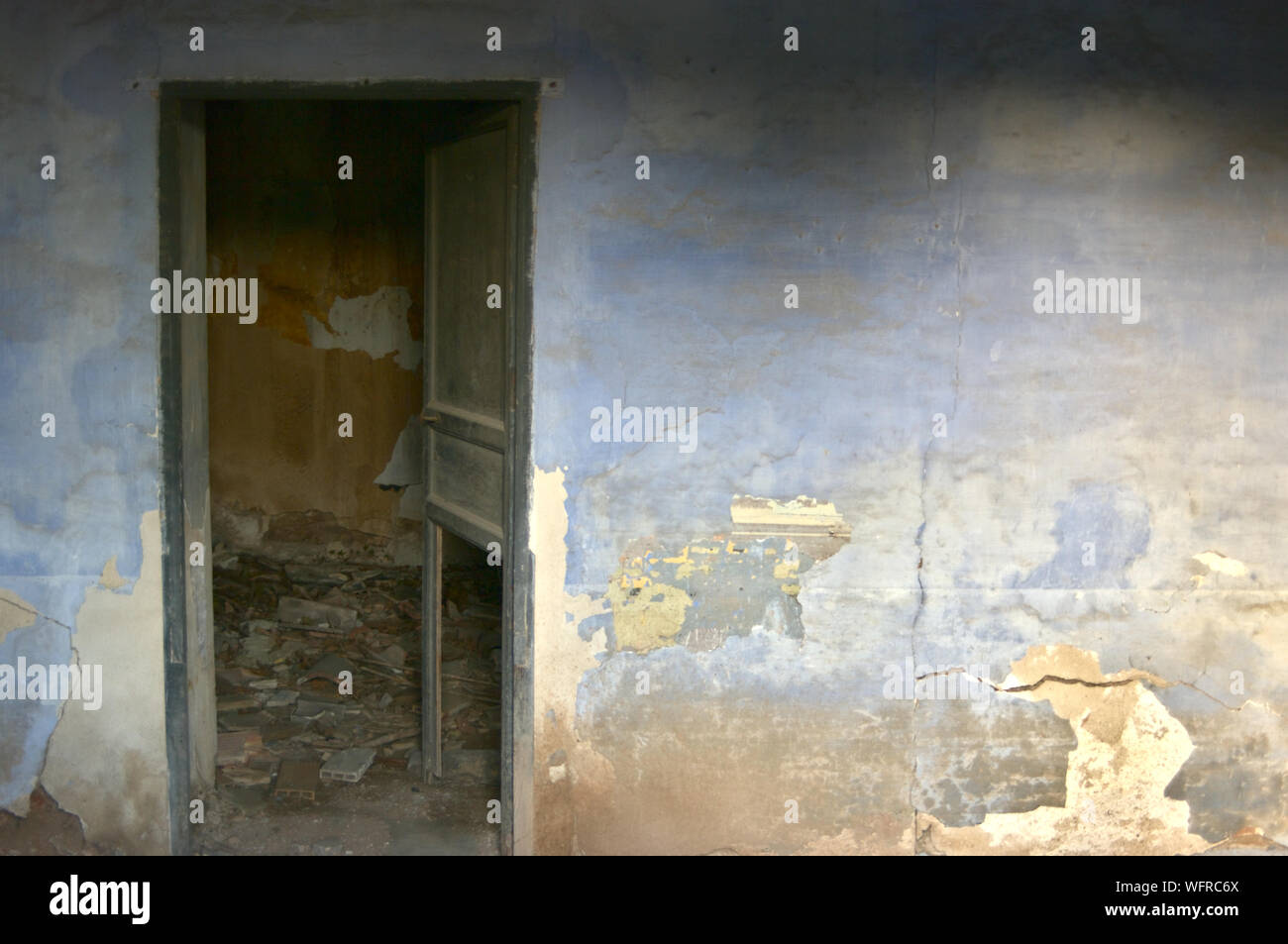 room wall with deteriorated paint and open door for backgrounds and ...