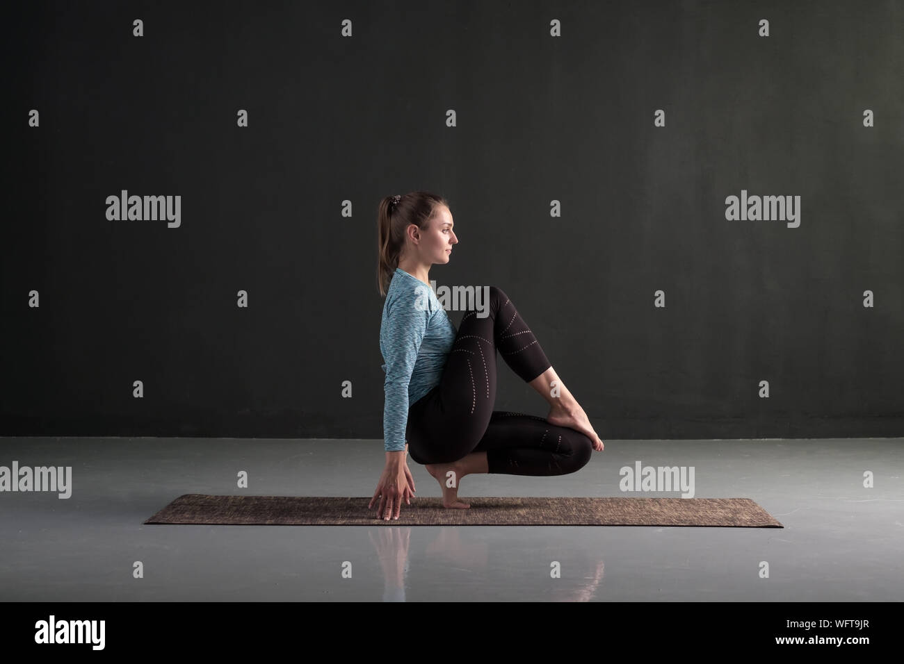 Young girl practicing yoga standing in Toe Balance exercise or Toestand ...