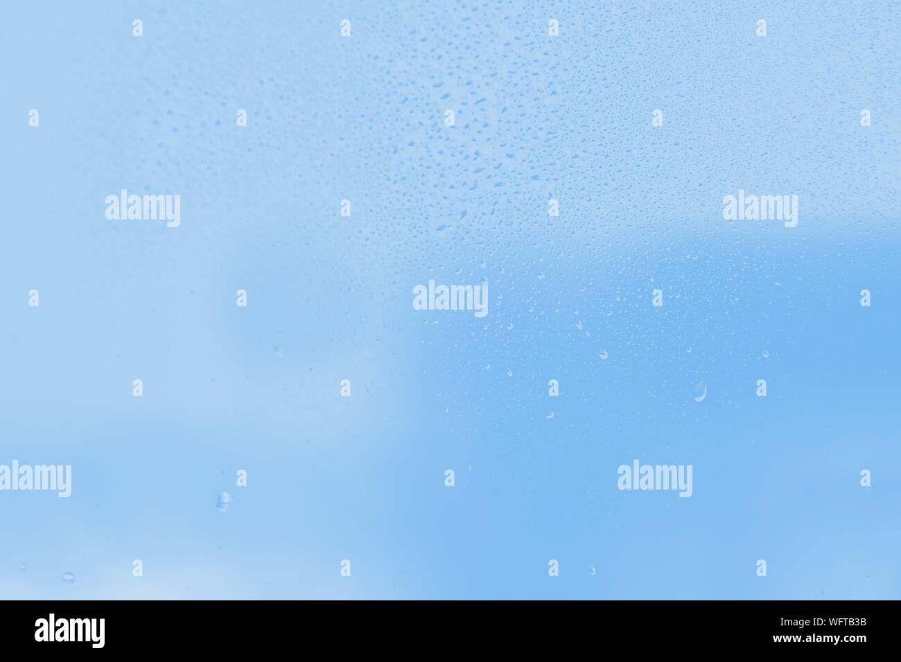 Raindrops on window glass. Blue gradient background Stock Photo - Alamy