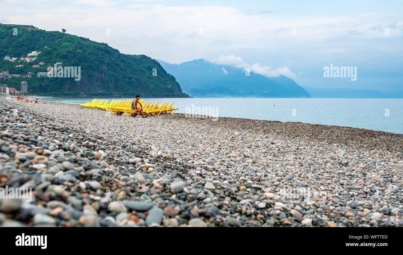 beautiful view of the stony beach in kvariati, Adjara. deck chairs on ...