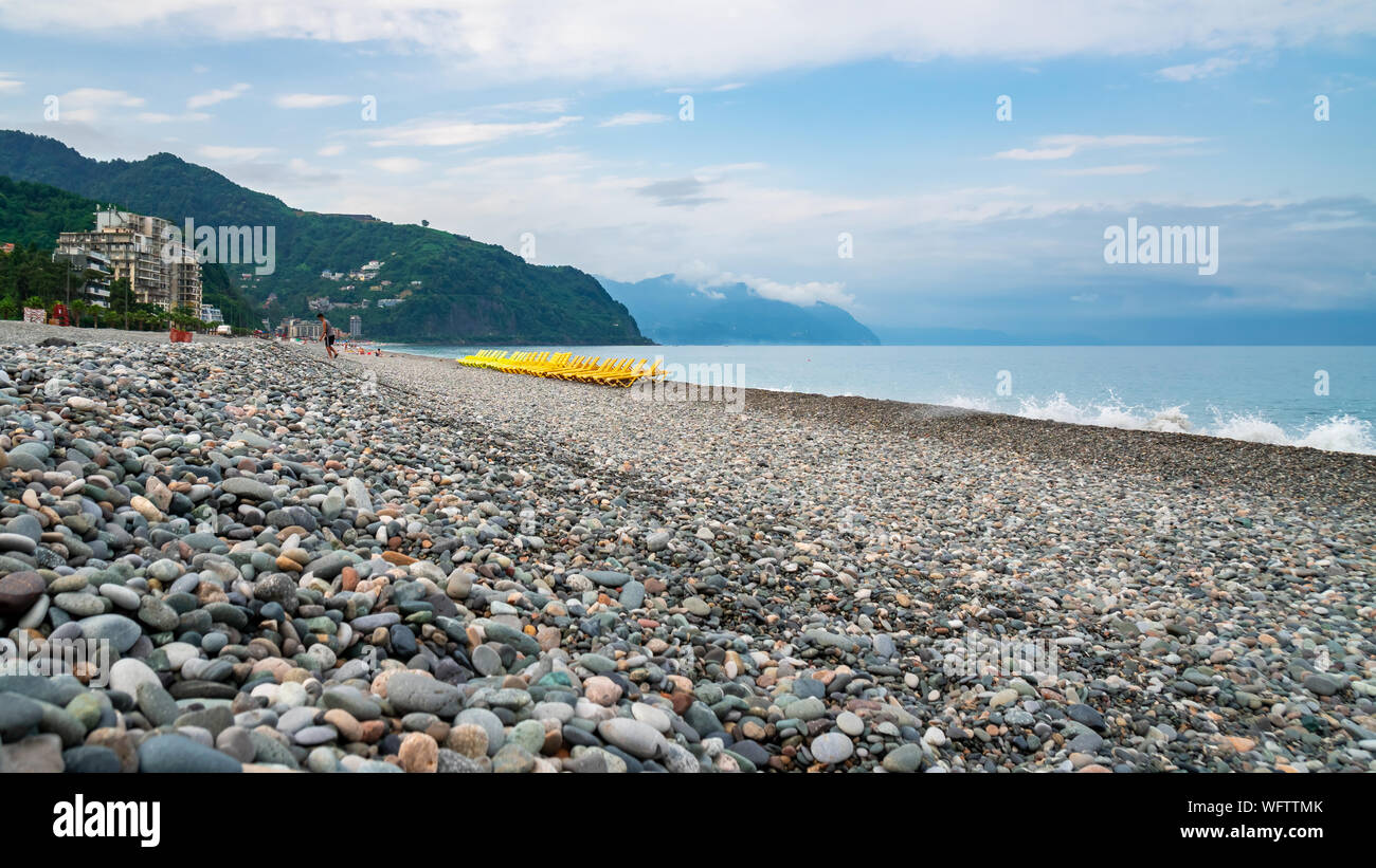 beautiful view of the stony beach in kvariati, Adjara. deck chairs on ...
