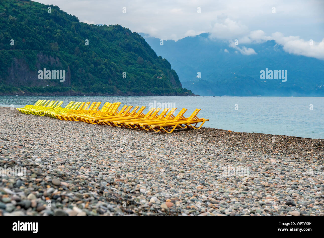beautiful view of the stony beach in kvariati, Adjara. deck chairs on ...
