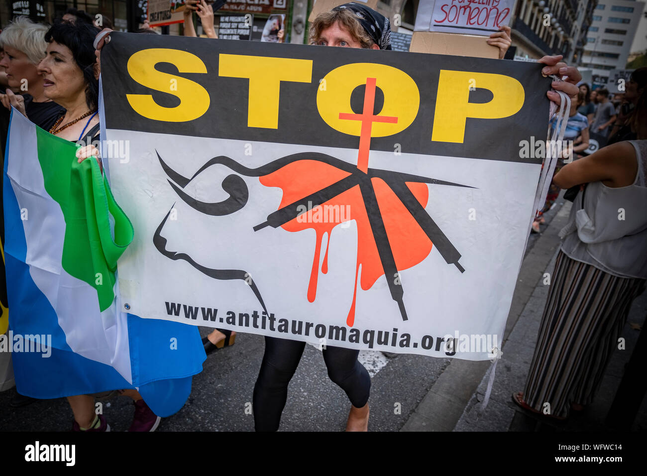 A protester holds a placard against bullfighting during the ...