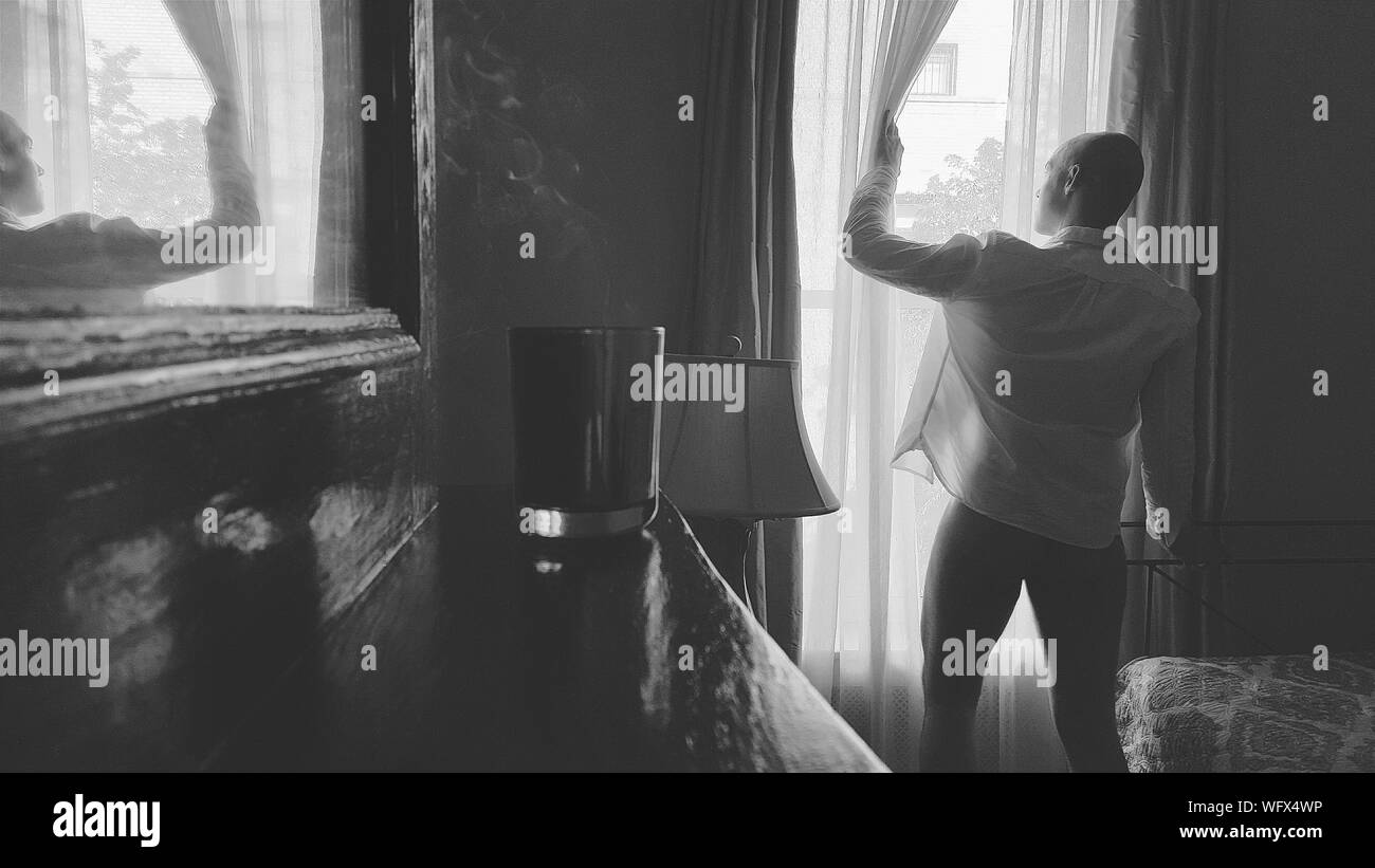 Man looking through window Black and White Stock Photos & Images - Alamy