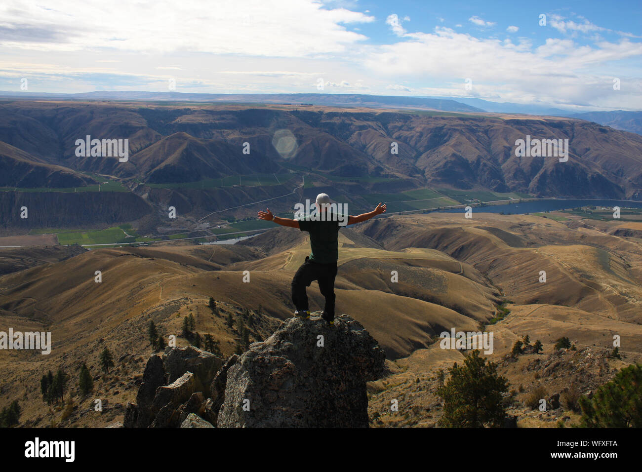 Man standing on cliff arms hi-res stock photography and images - Alamy