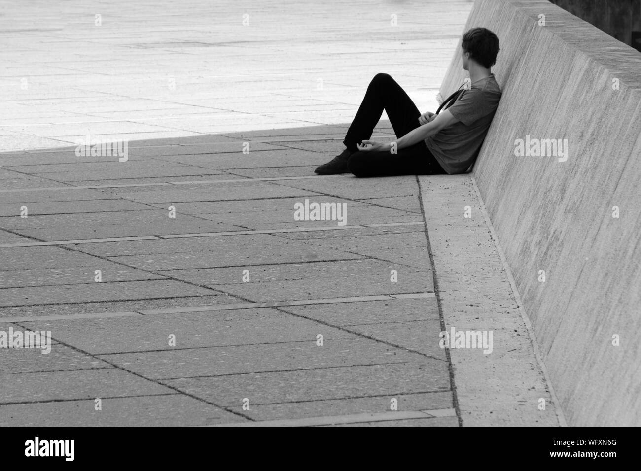 People sitting shadow wall Black and White Stock Photos & Images - Alamy