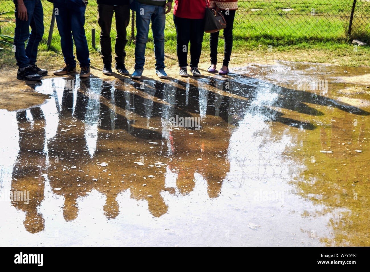 Low Section Of People Standing By Puddle Stock Photo - Alamy