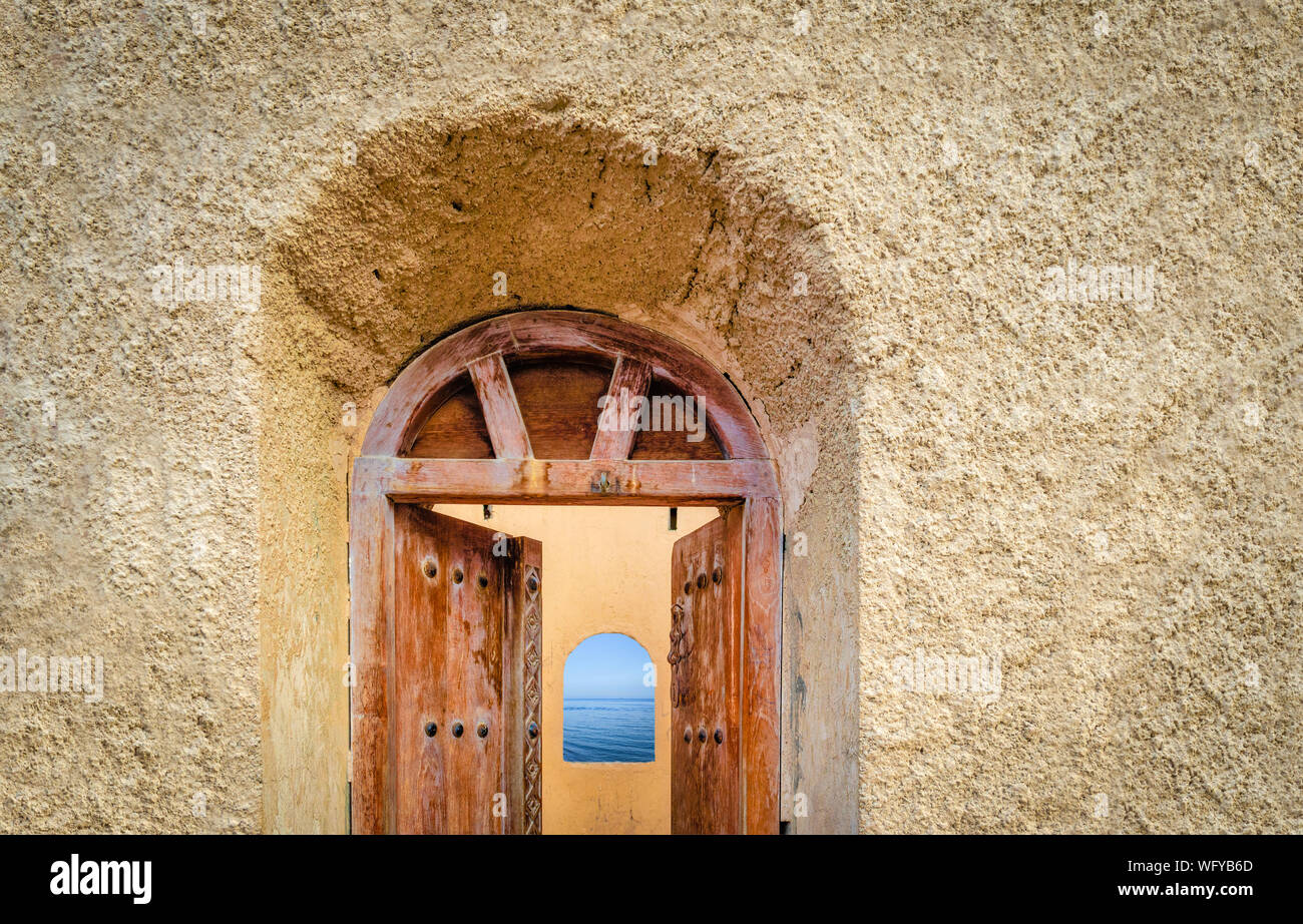 Old, antique door of a watchtower opening to reveal a arch window to ...
