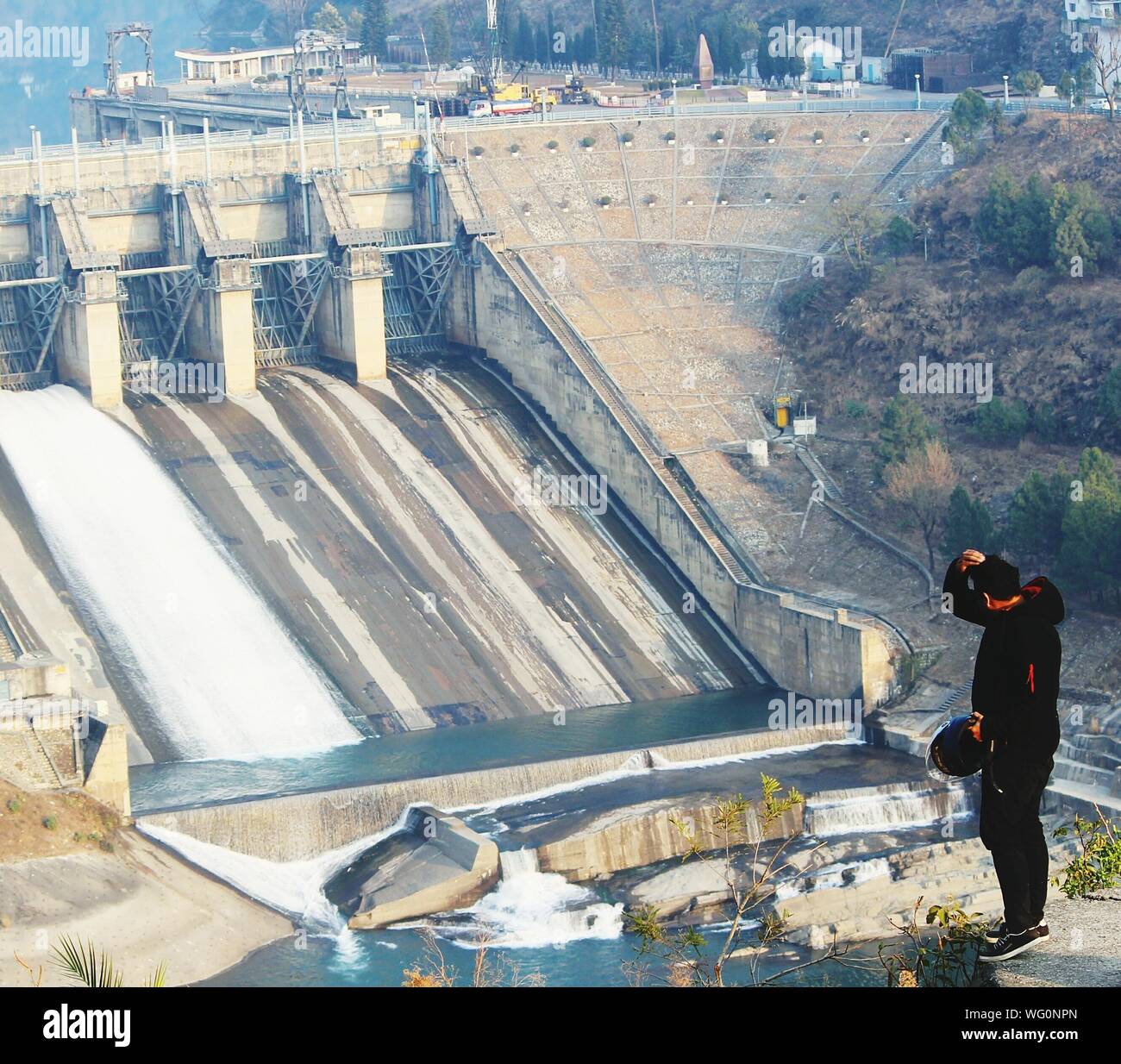 Man Standing On Cliff In Front Of Dam Stock Photo - Alamy