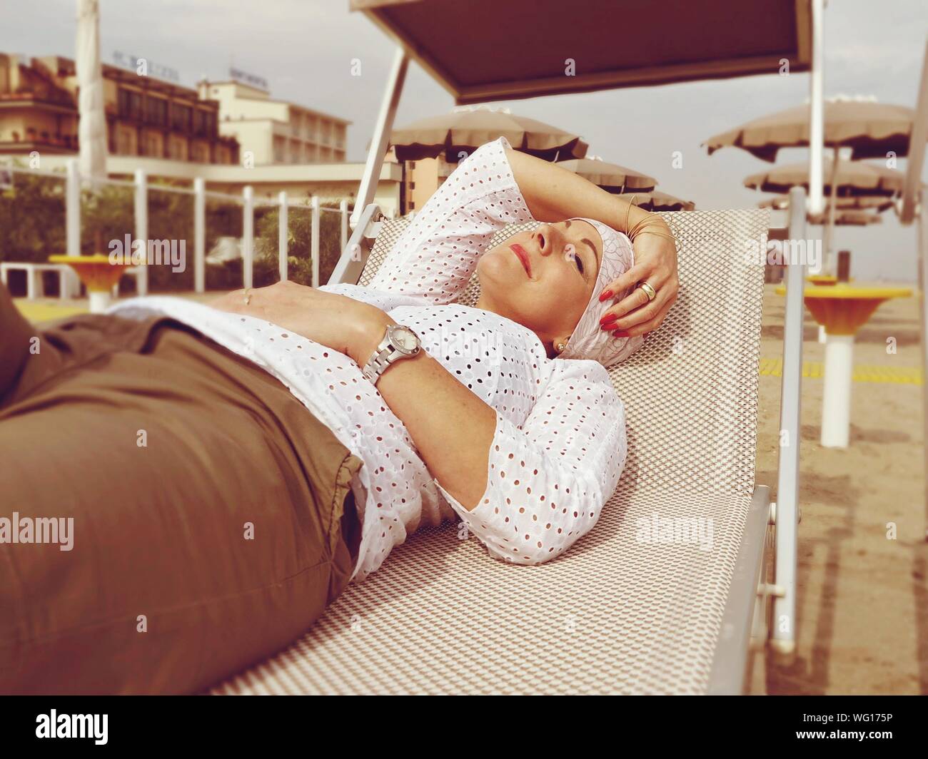 Woman lying on beach chair hi-res stock photography and images - Alamy