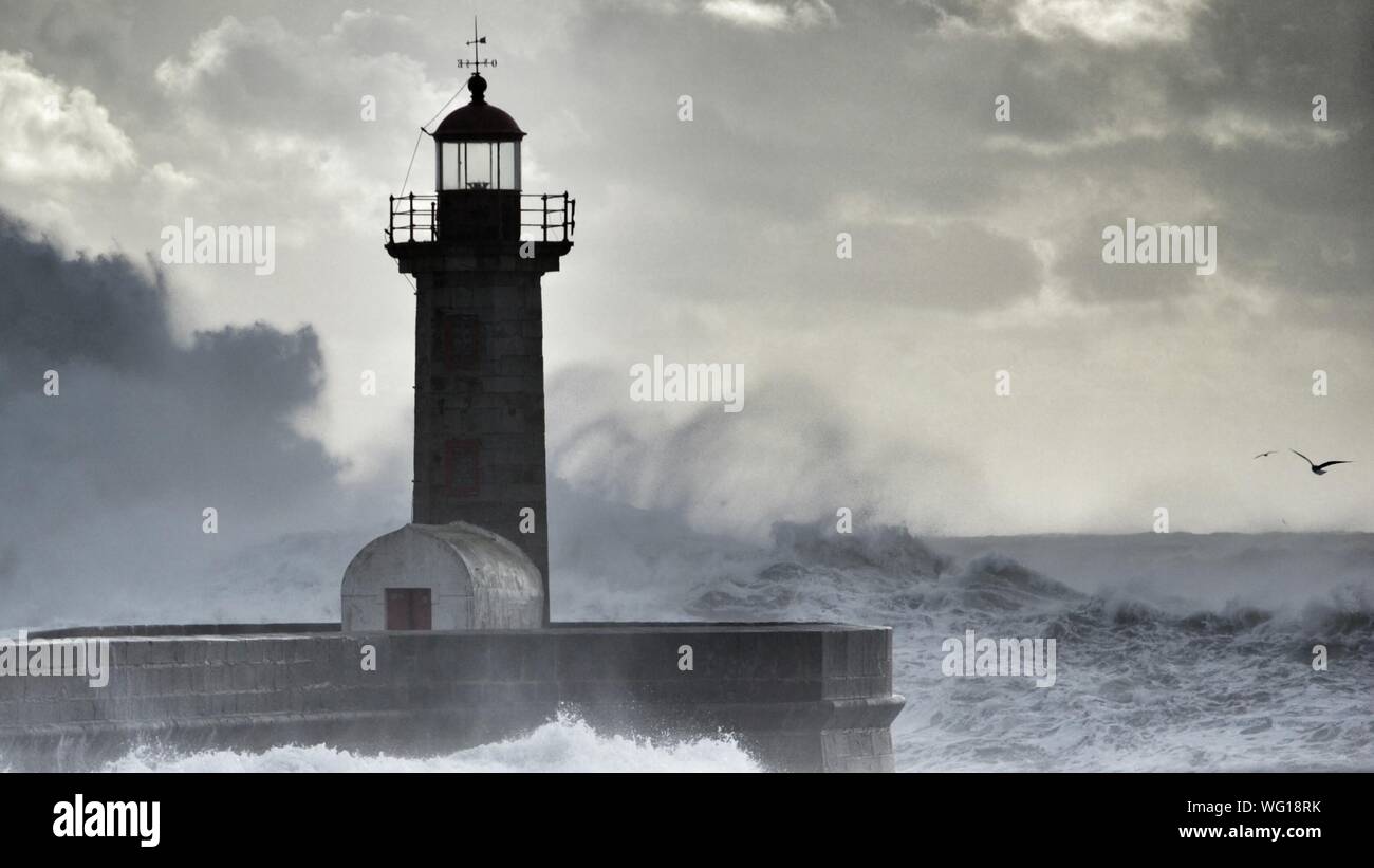 Lighthouse in breaking waves hi-res stock photography and images - Alamy