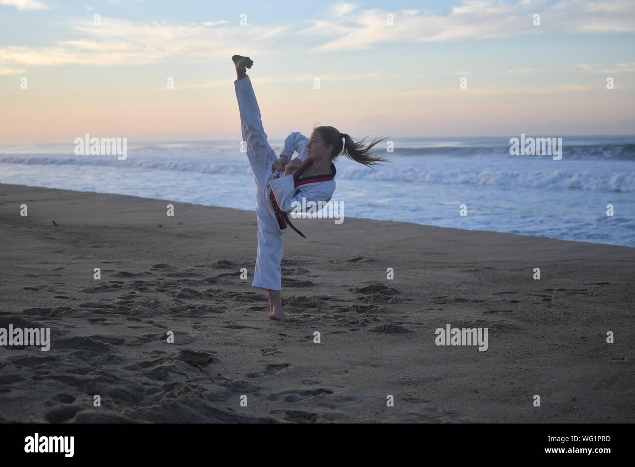 Young Woman Practicing Martial Arts On The Beach High Resolution Stock ...