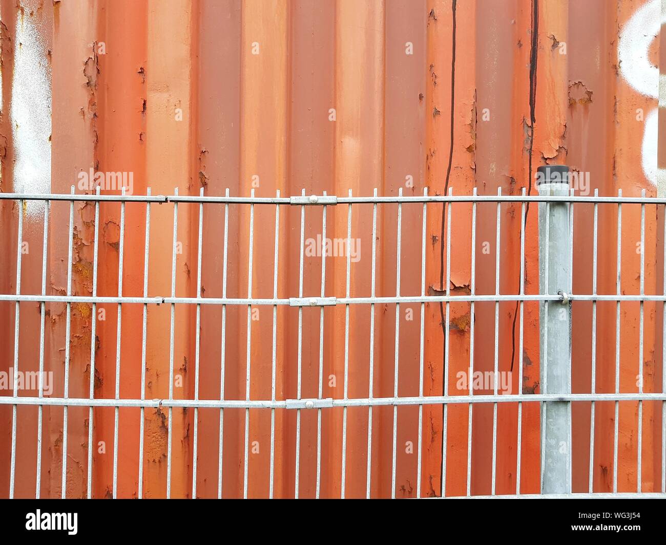 Metallic Fence Against Corrugated Iron Container Stock Photo - Alamy
