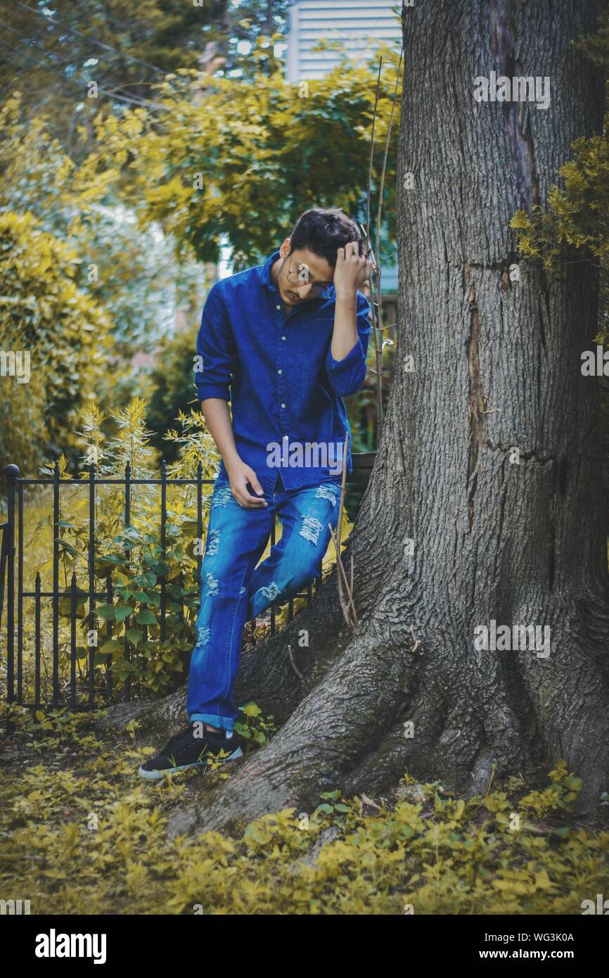 Young man sitting on fence hi-res stock photography and images - Alamy