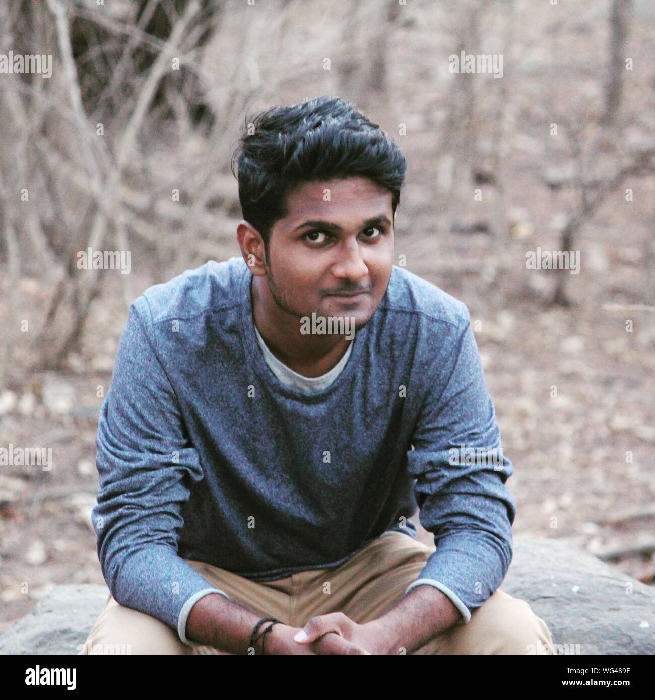 Young man sitting on rock hi-res stock photography and images - Alamy