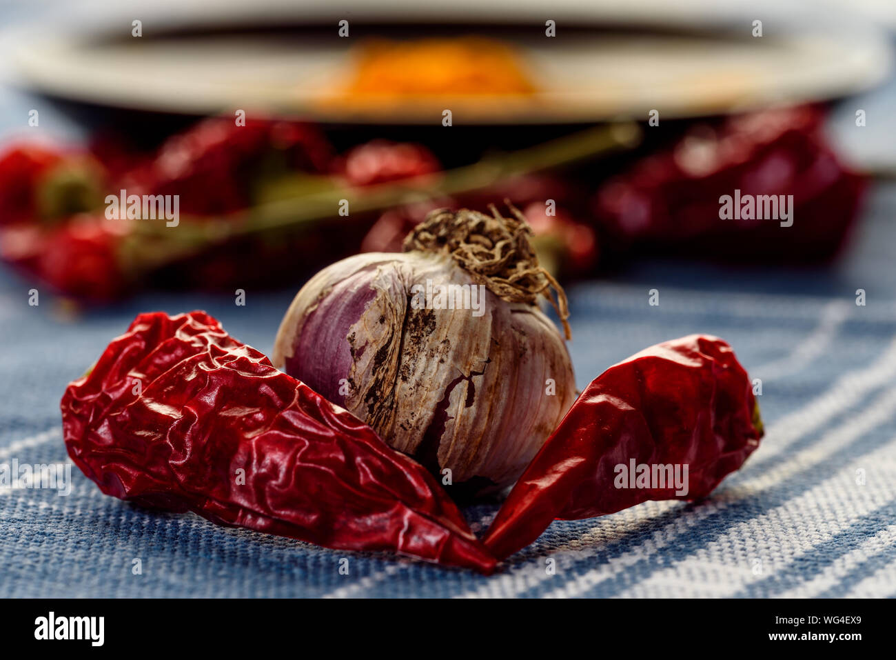 still life with garlic and chili pepper over a blue tablecloth. cooking ...