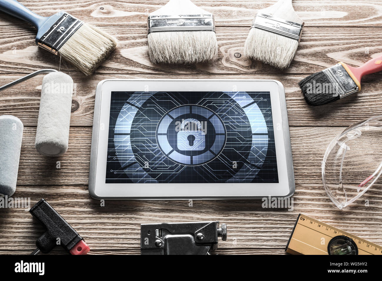Tablet pc with security concept on screen and industrial tools around ...