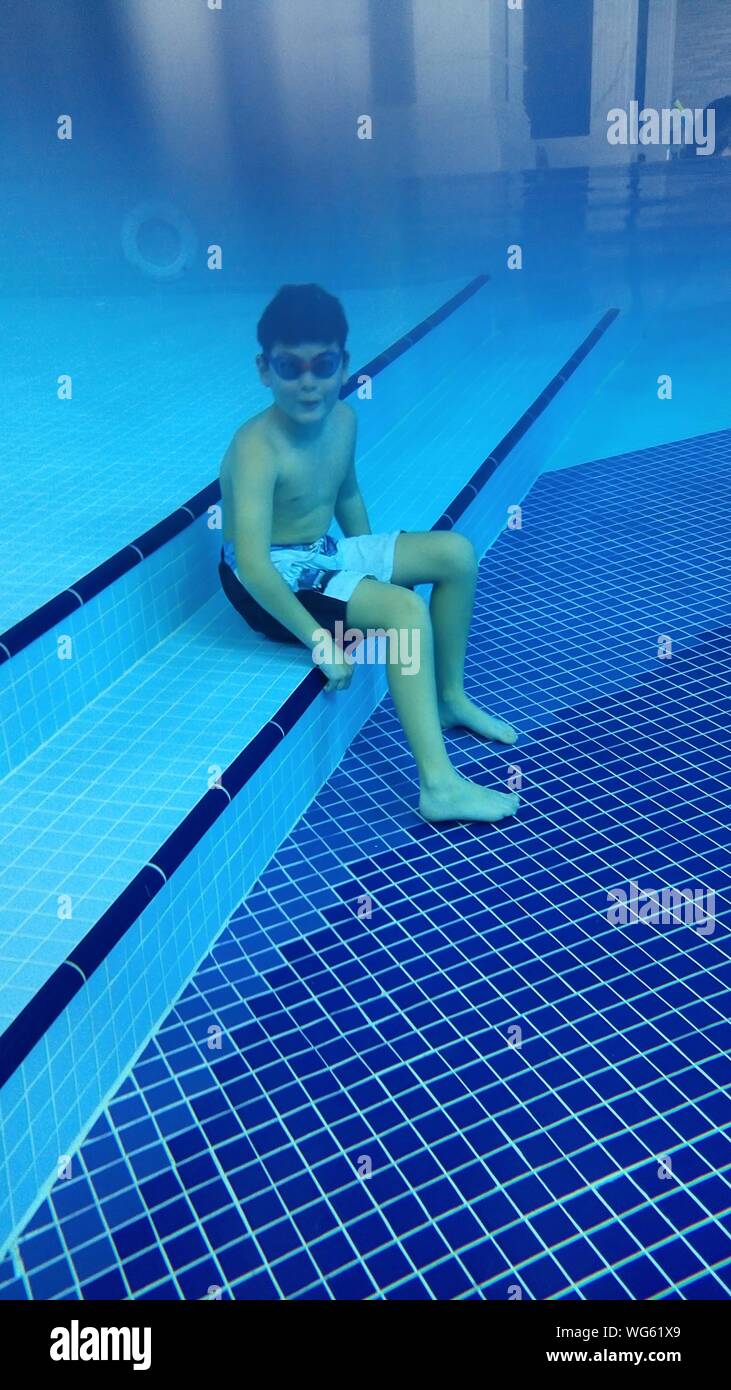 Boy Sitting In Swimming Pool Stock Photo - Alamy