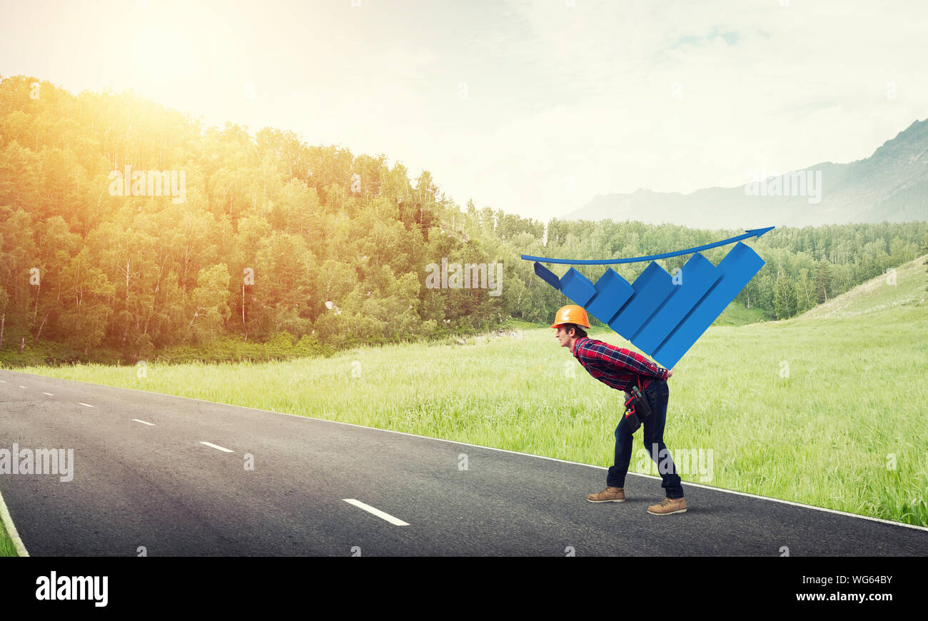 Young man builder carrying growing graph on his back Stock Photo - Alamy