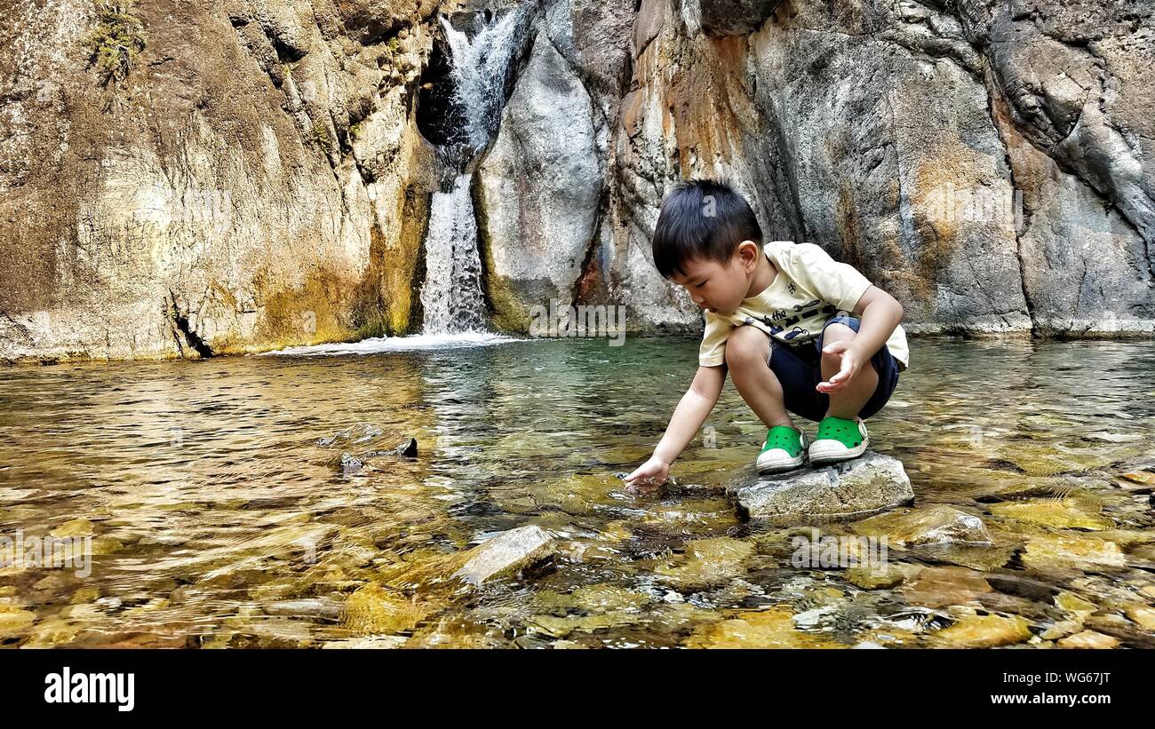 Boy playing by river hi-res stock photography and images - Alamy