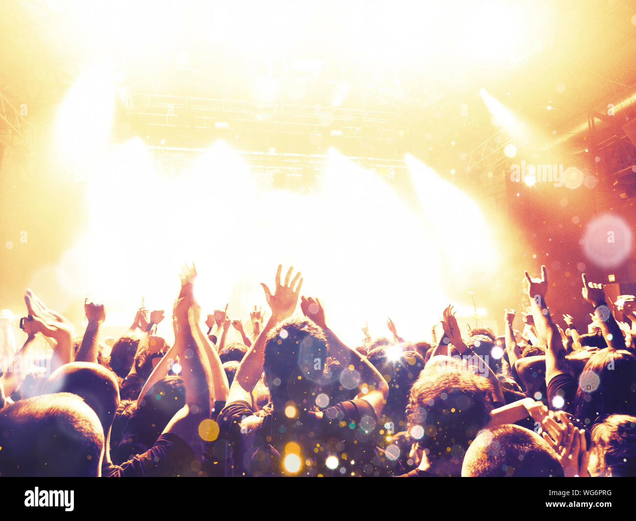 Concert crowd clapping in front of a bright stage Stock Photo - Alamy