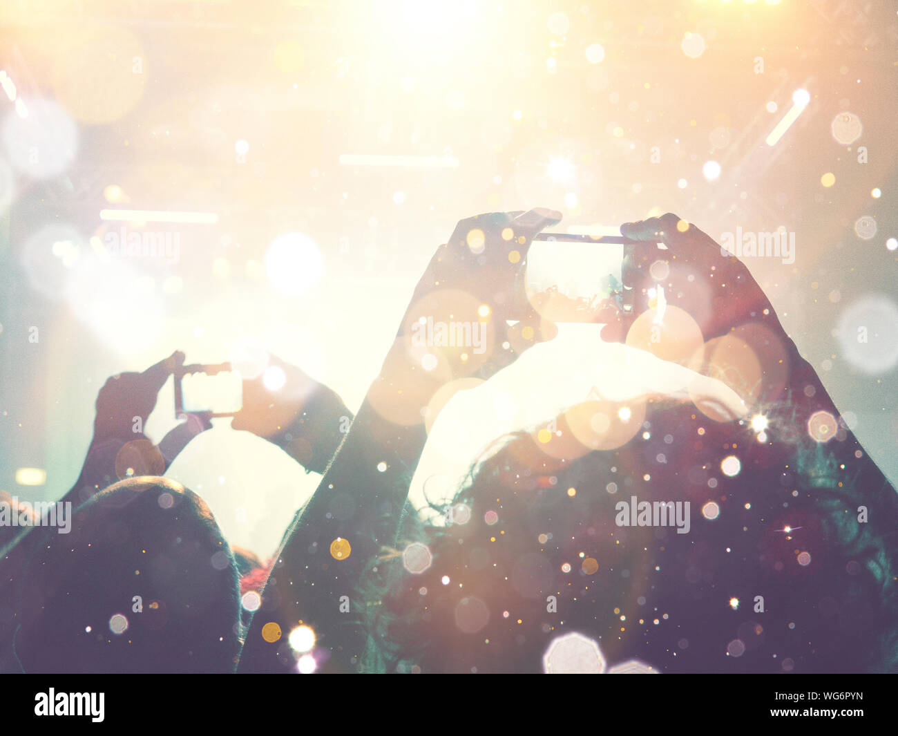 Concert crowd clapping in front of a bright stage Stock Photo - Alamy